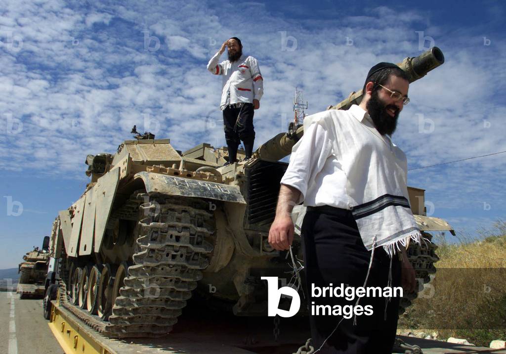 Image of Ultra-Orthodox Jews stand on a an Israeli army "Merkava" tank