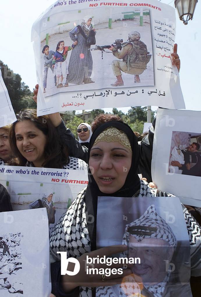 Image of A GROUP OF ARAB WOMEN CARRYING A POSTER OF PALESTINIAN
