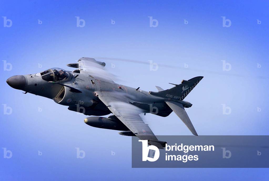 Image of A BRITISH ROYAL NAVY HARRIER JUMP JET HOVERS OVER THE