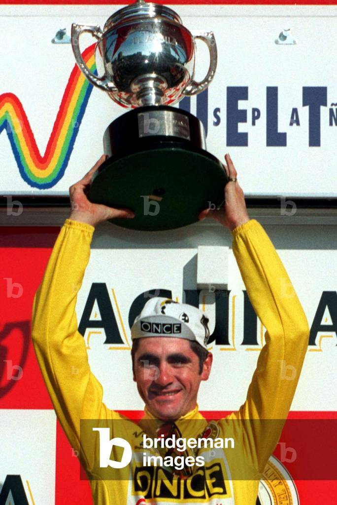 Image of Frenchman Laurent Jalabert smiles as he lifts up the trophy