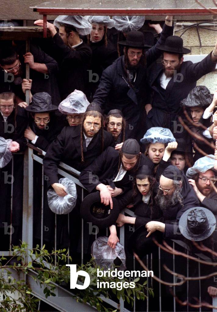 Image of Ultra-religious Jewish men crowd an outdoor staircase for a last