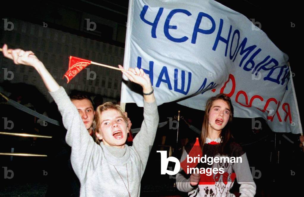 Image of Russian girls shout out slogans as they wave Soviet red