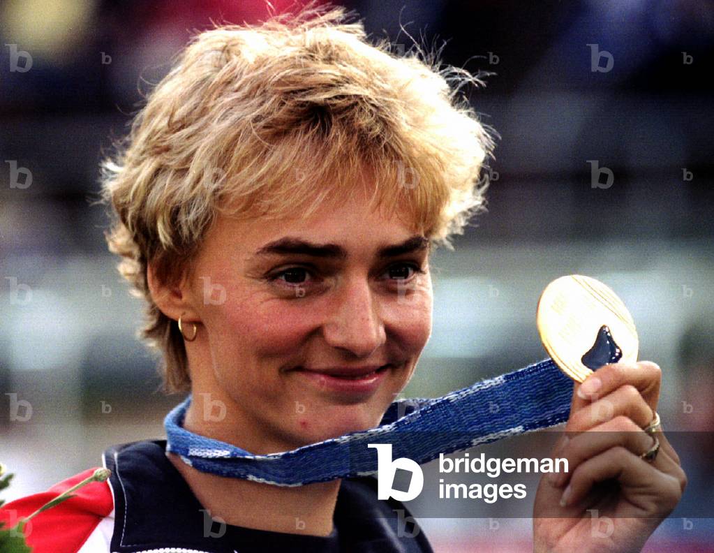 Image of Heike Drechsler of Germany shows her gold medal after winning