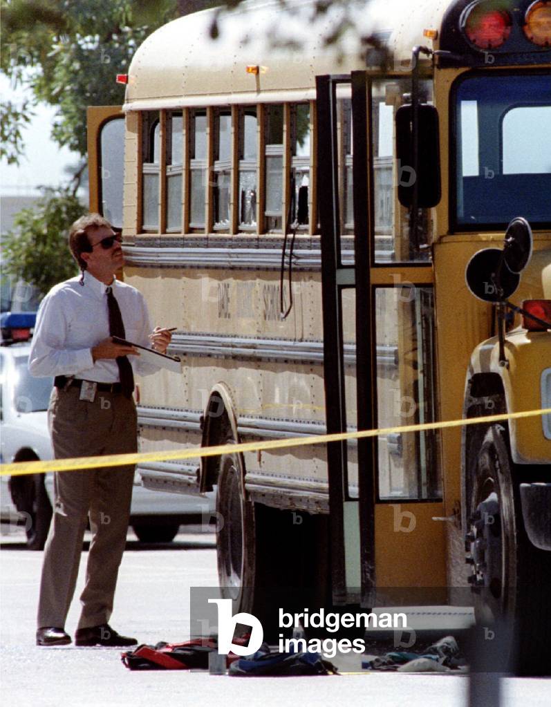 Image of A Metro-Dade Police detectiveexamines a school bus where a man