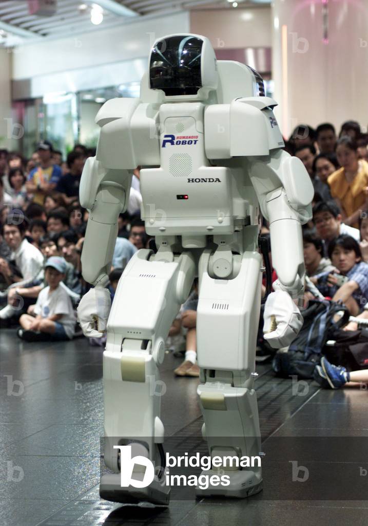 Image of Honda's humanoid robot P3 walks past a crowd of onlookers