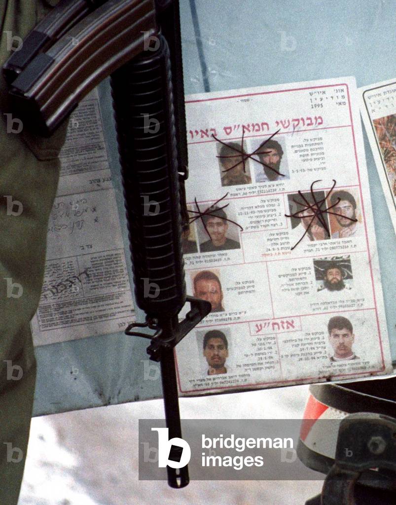 Image of An Israeli Border-policeman carries a wanted poster of ...