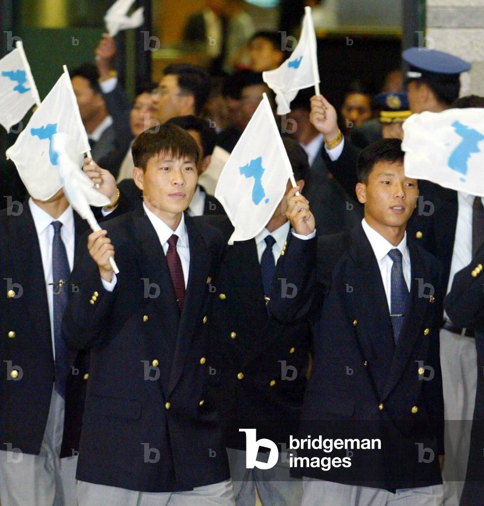 Image of NORTH KOREAN SOCCER PLAYERS WAVE UNIFICATION FLAGS UPON THEIR ...