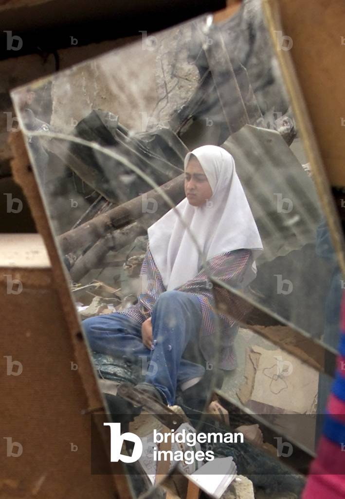 Image of A PALESTINIAN SCHOOLGIRL IS REFLECTED IN A MIRROR AFTER ISRAELI