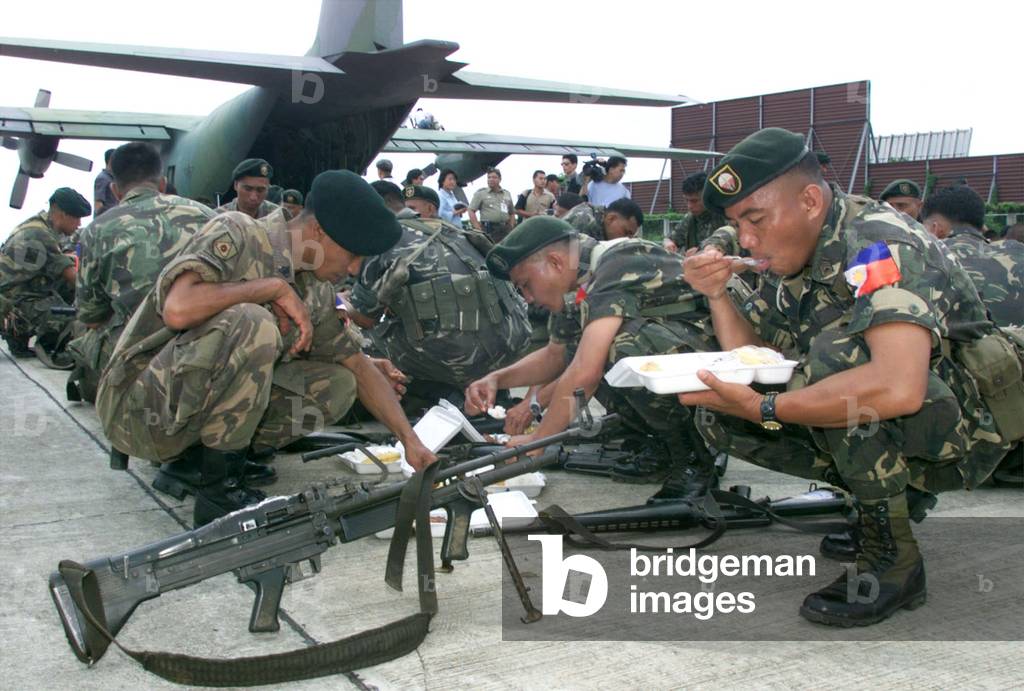 Image of FILIPINO SOLDIERS EAT LUNCH IN MAINLA BEFORE FLYING TO DARWIN,