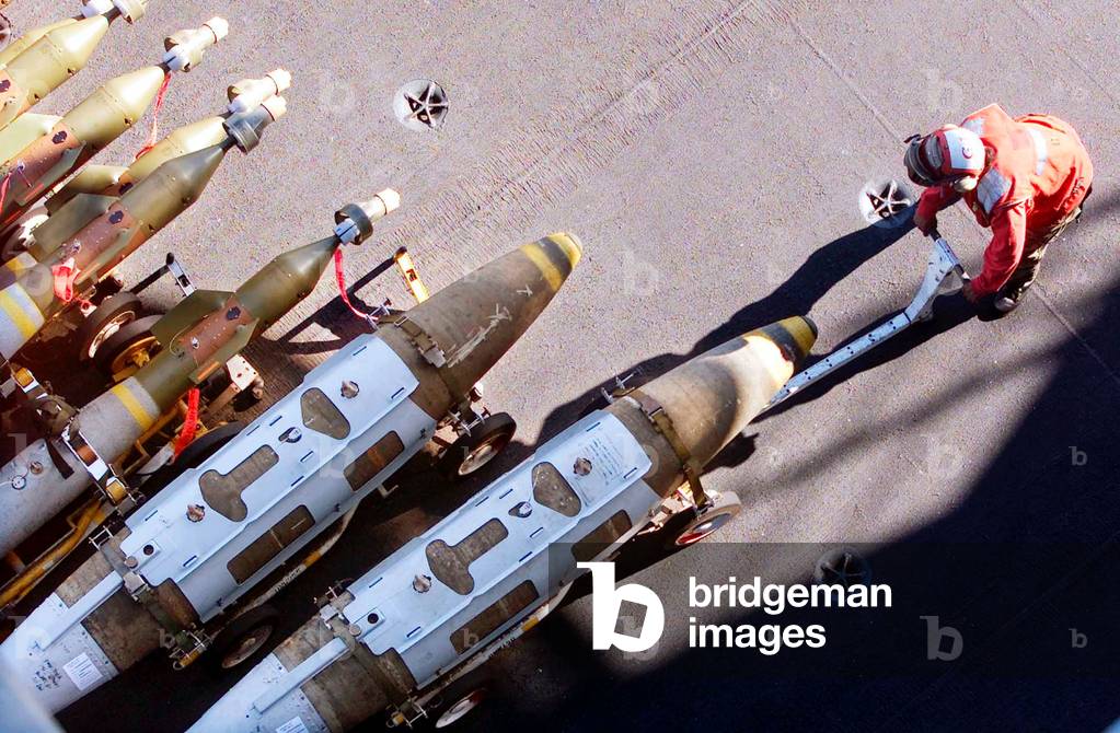 Image of A SAILOR ABOARD THE USS THEODORE ROOSEVELT MOVES A BOMB,