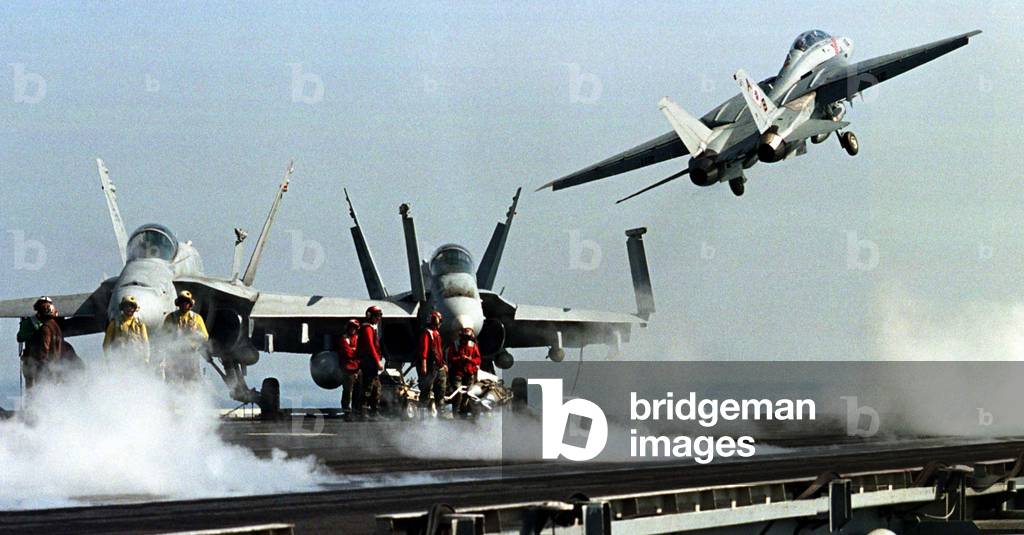 Image of A US Navy F-14 jet fighter lifts off from the