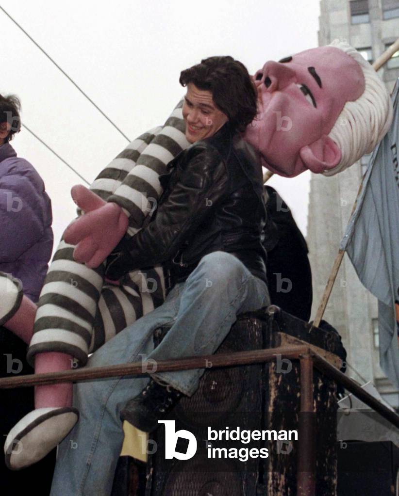 Image of Dejan Bulatovic, a 21-year old worker holds an effigy of