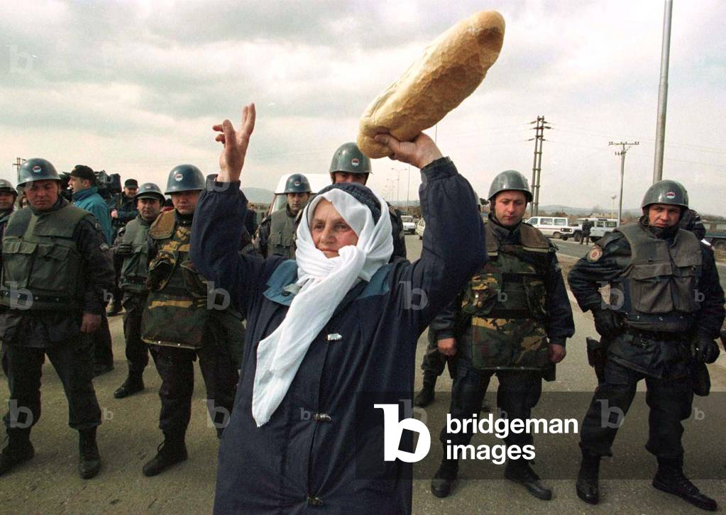 Image of An ethnic Albanian woman makes a victory sign as she