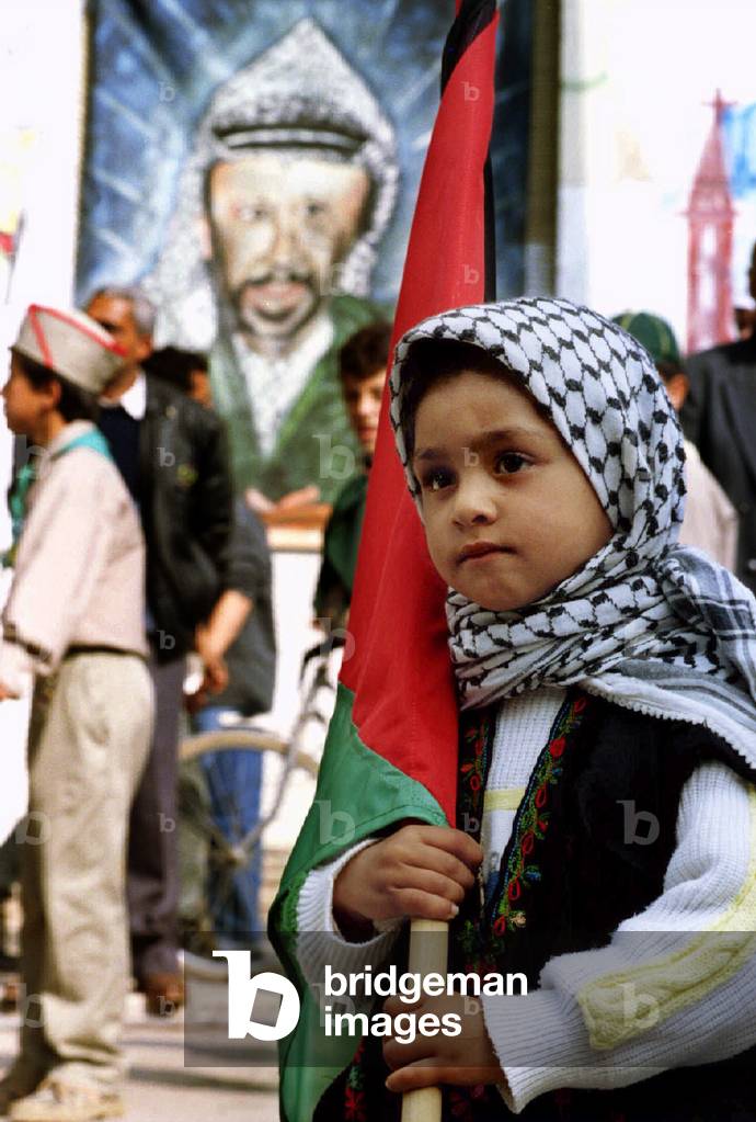 Image of A young Palestinian girl in a "Fatah Day" parade carries