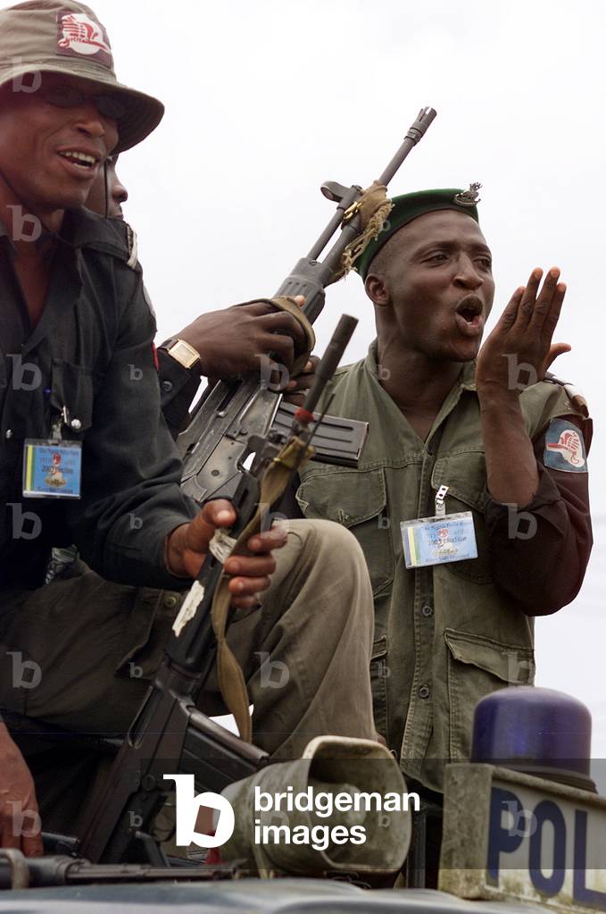 Image of NIGERIAN MOBILE POLICEMAN ULULATES AS HIS VECHICLE MOVES OFF ON