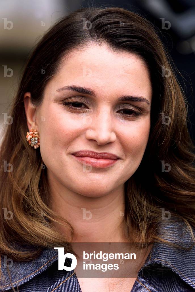 Image of Queen Rania of Jordan smiles as she watches [Prince Hashim