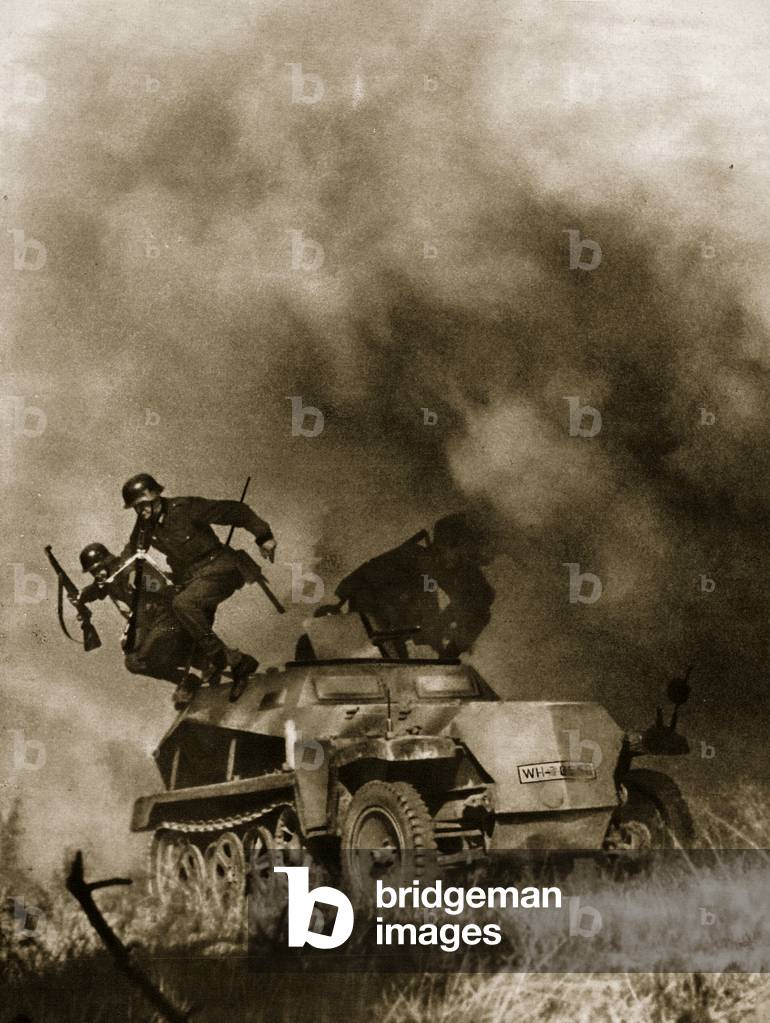 Image of A crew jumps out of an armoured vehicle during the