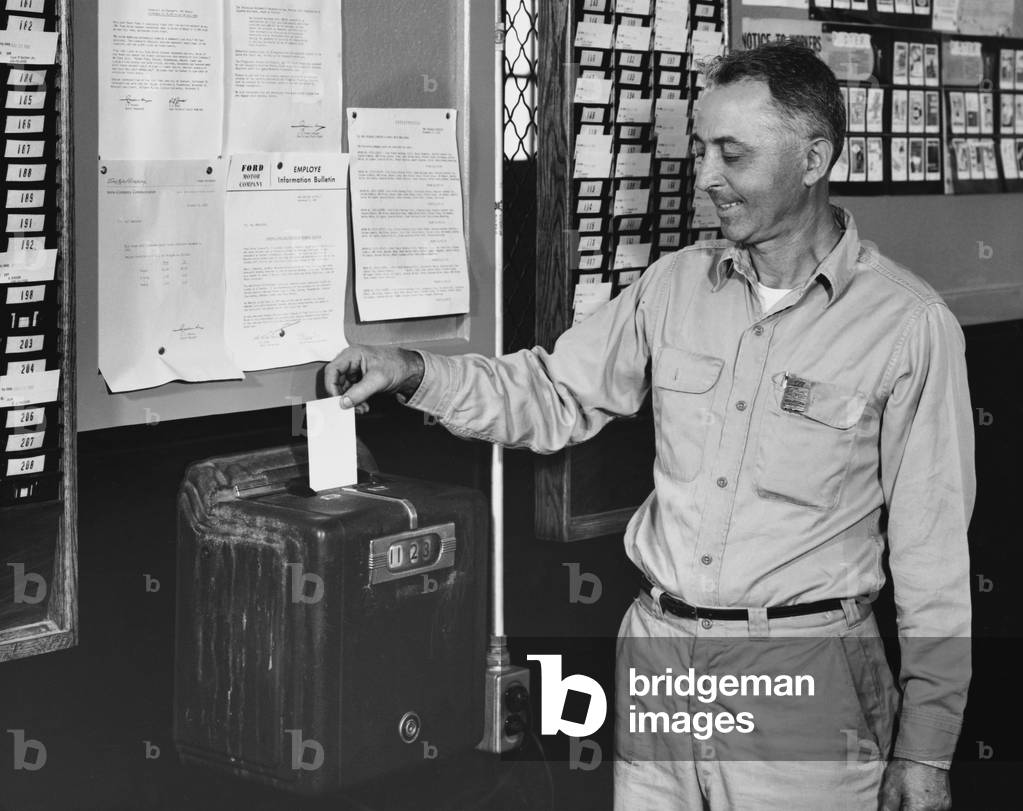 Image of Mature man punching a time card