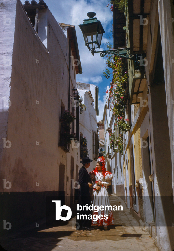 Image of Spanish young couple in traditional dress courting in a narrow ...