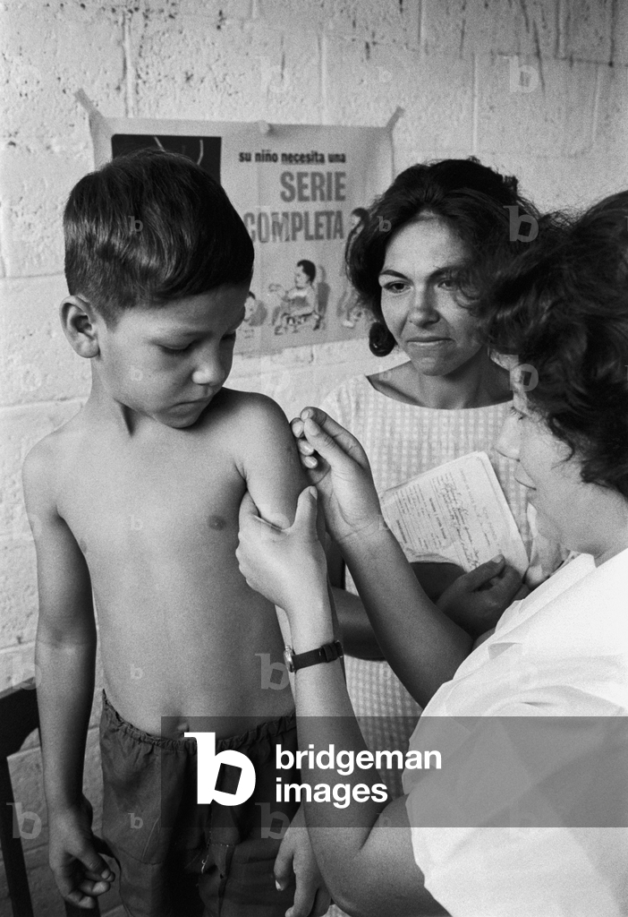 Image of Nurse inoculates an Equadorian boy with vaccine on mission ...