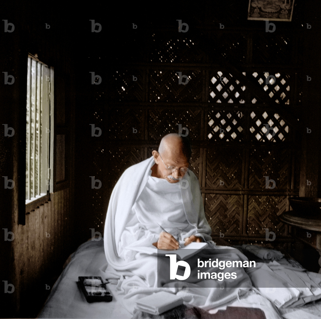 Image of Mahatma Gandhi sitting and writing in his hut, Bangladesh 1946