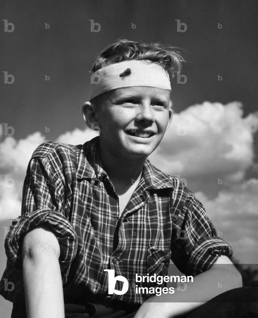 Image of Close-up of a teenage boy with bandage around his forehead