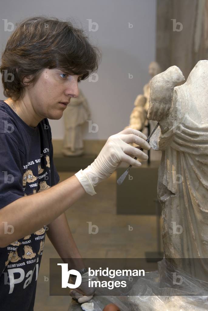 Image of Archaeologist carrying out restoration work on an artefact at ...