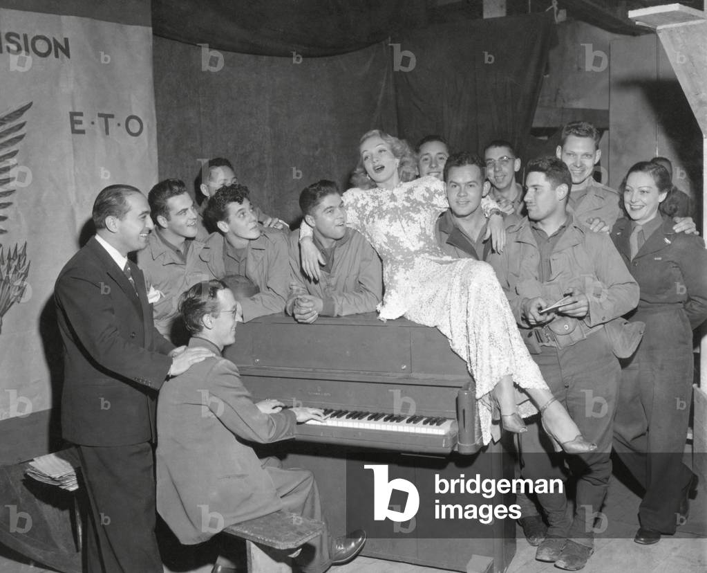 Image of L'actrice Marlene Dietrich chante pour un groupe de GI en