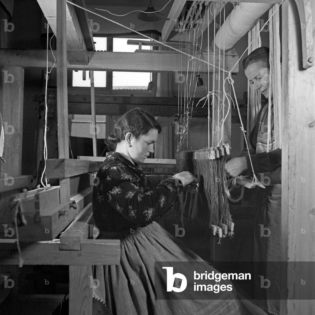 Image of Two women at a weaving loom at the school for