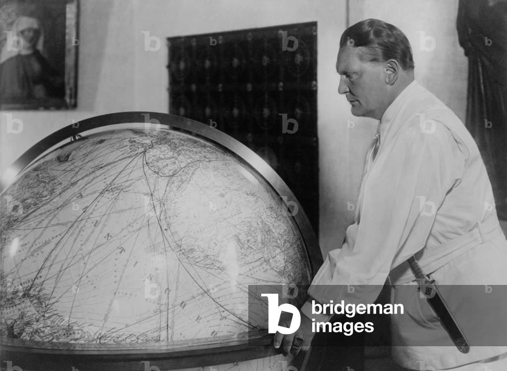 Image of Hermann Goering, leaning toward a large globe in 1939. He