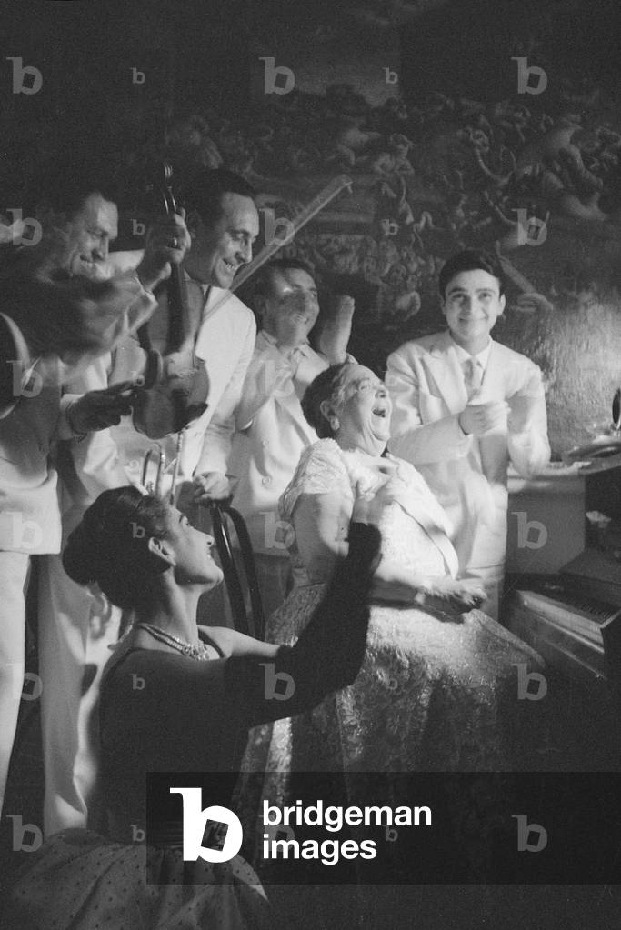 Image of Maria Callas listenig to Elsa Maxwell playing, Italy, 1957 (b/w