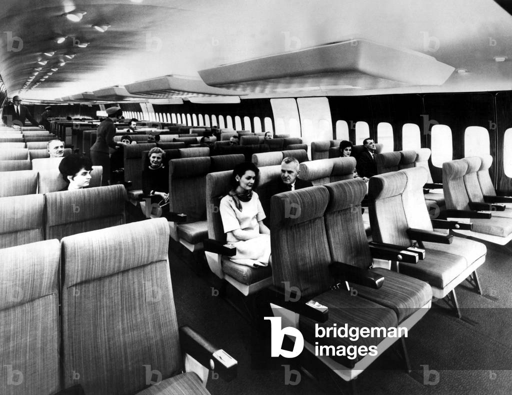 Image of Passengers sit inside the massive interior of the Boeing 747.
