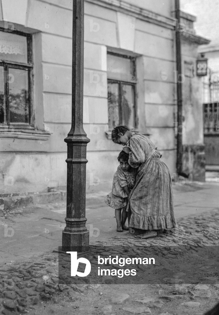 Image of Children poorly dressed and dirty, girl checking for lice in ...