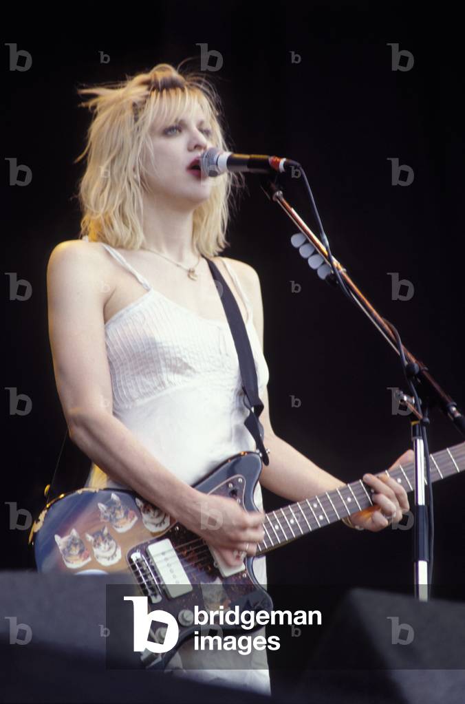 Image of Courtney Love, lead singer of 'Hole', singing and playing electric