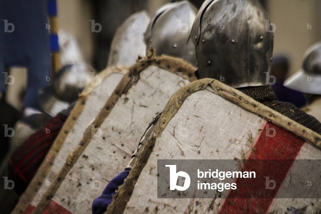 Image of Historical reenactment: Column of soldiers wearing helmets and ...