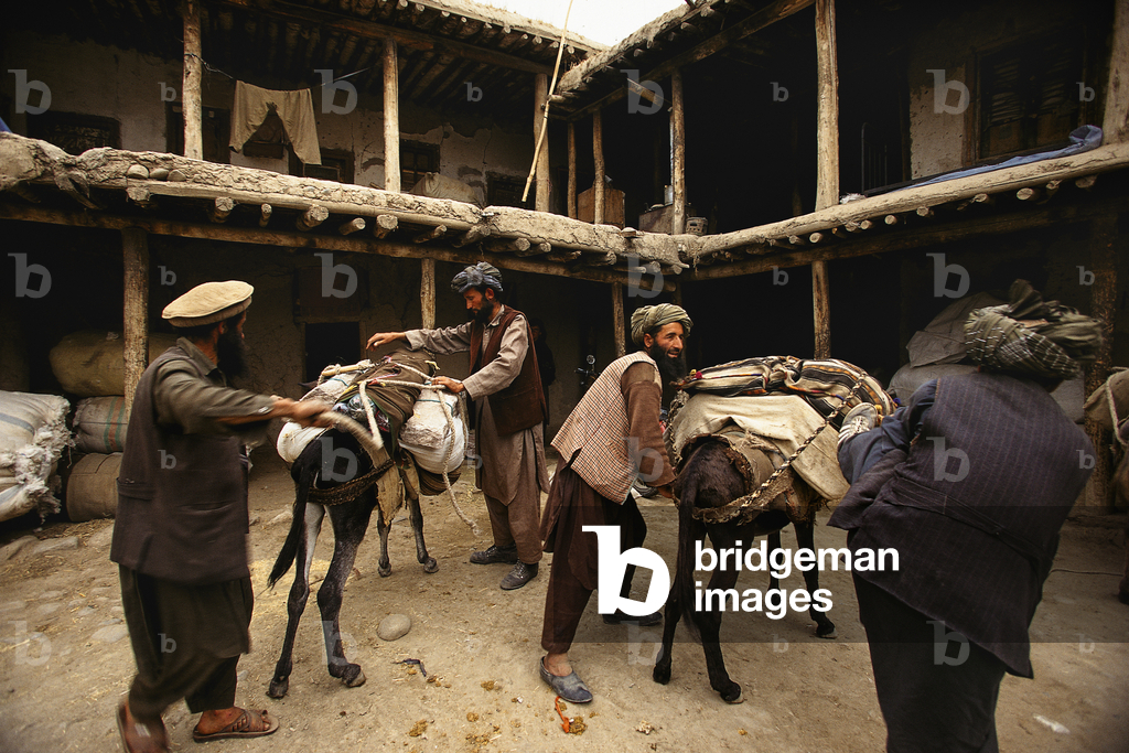 Image of Mules are loaded with salt in the courtyard of a by Yamashita ...