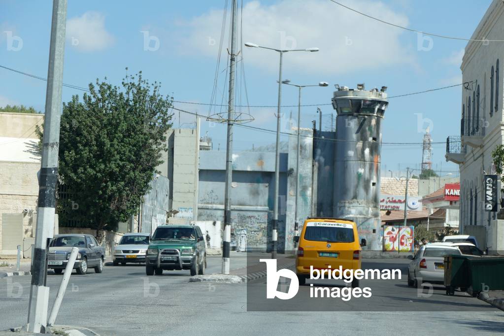 Image of Guard tower at the entrance to a walled refugee camp