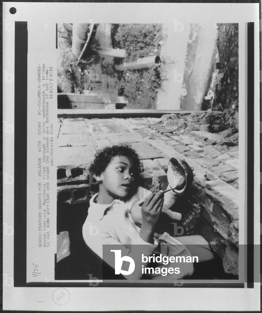 Image of 7 yr old Marchela slips through a hole underneath a by Diaz ...