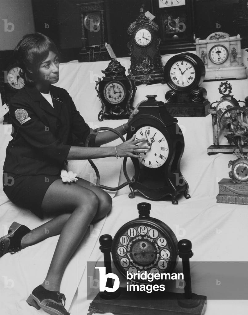 Image of A Museum Employee Setting The Time On One Of The