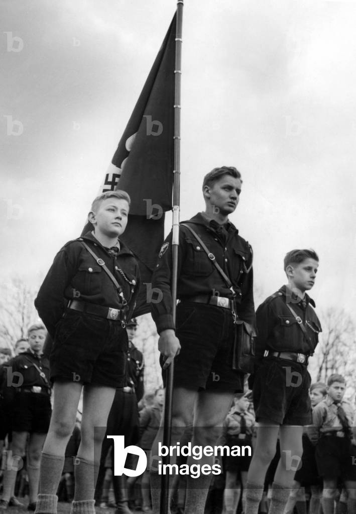Image of Jungvolk leader and Pimpfe with swastika flag, 1943 (b/w photo)