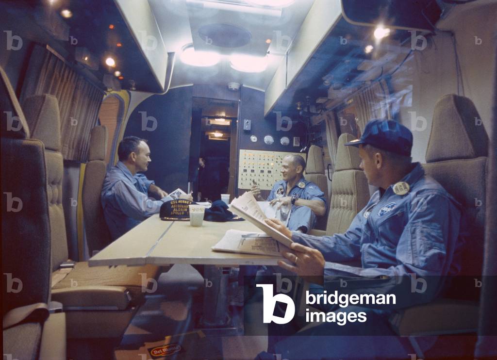 Image of Apollo 11 Astronauts in quarantine trailer on the USS Hornet.