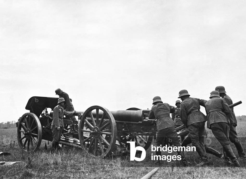 Image of Soldiers mount a cannon in attack position (b/w photo)