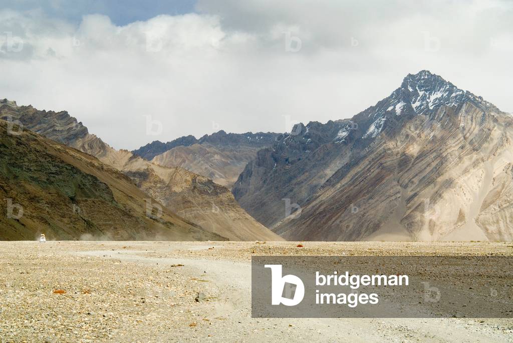 Image of Himalayan landscape: Loaded 4wd car crossing barren Rangdum ...
