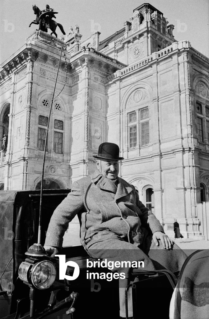 Image of Un Fiaker, cocher qui conduit un fiacre, devant l'opéra de by ...
