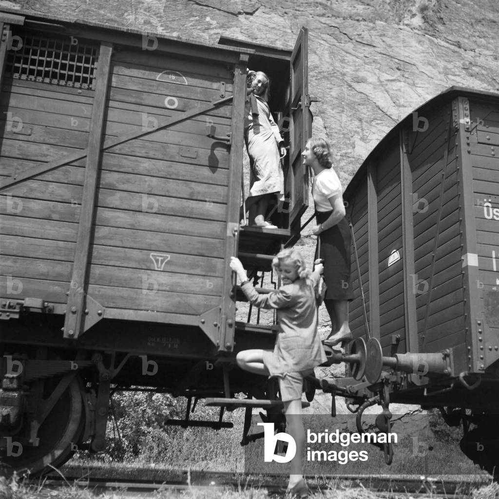 Image of Three young woman in a freight waggon of a train