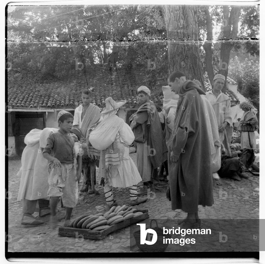 Image of Children obtaining food from a Holy man, on the street, by