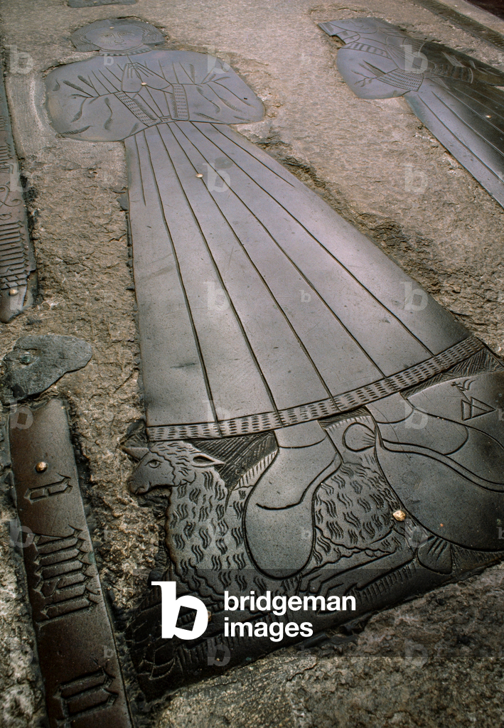 Image of A brass memorial shows a wool merchant with his foot by ...