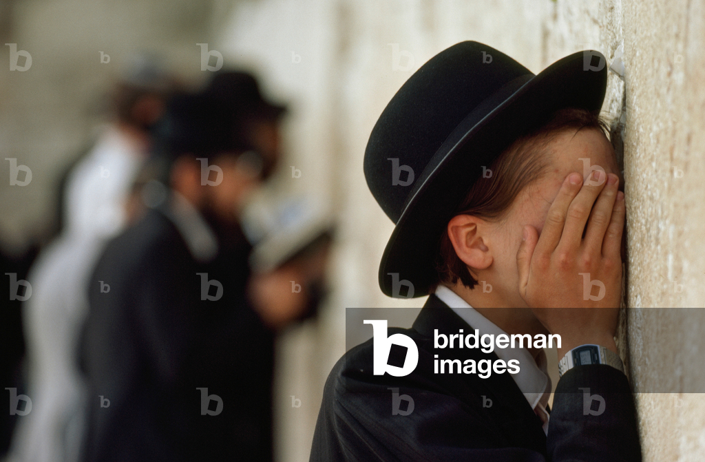 Image of A young ultra-Orthodox Jew covers his face, prays at the by ...