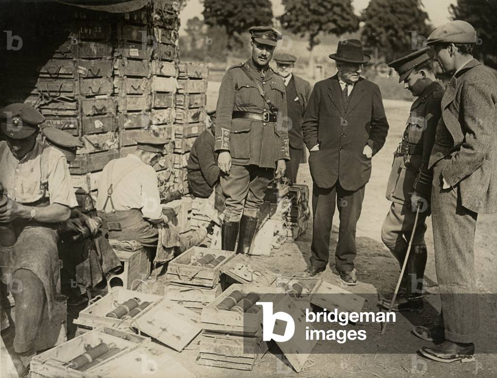 Image of Mr Asquith with men at work on fuses during the