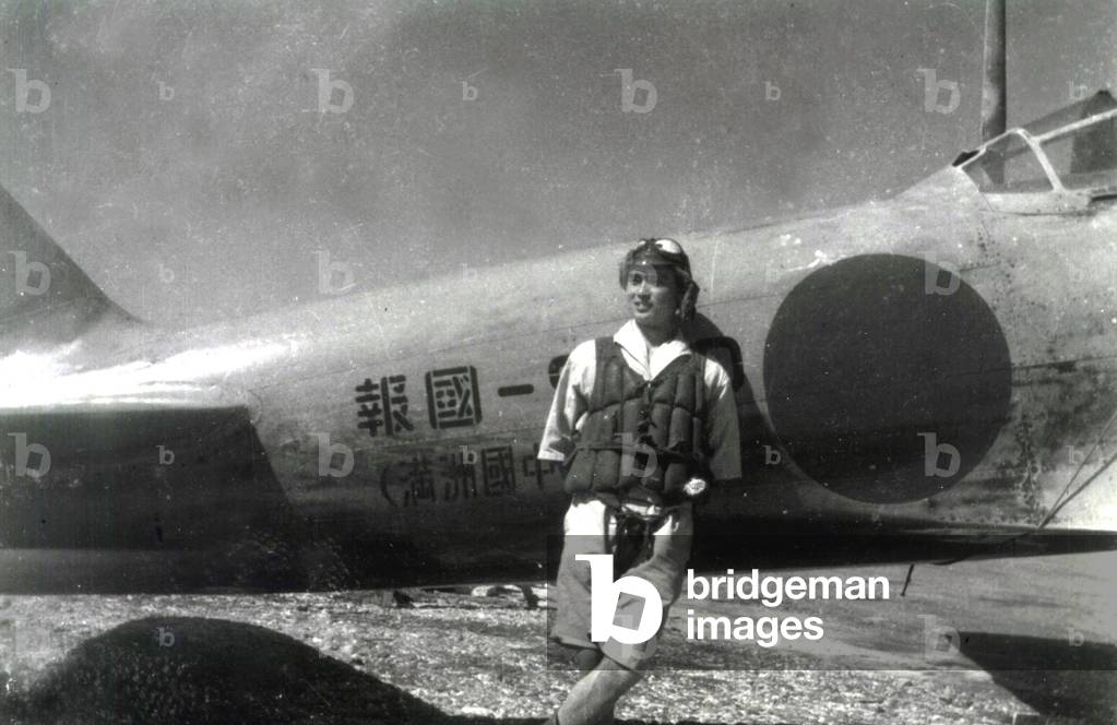 Image of World War II,Japanese pilot poses by Zero fighter in the